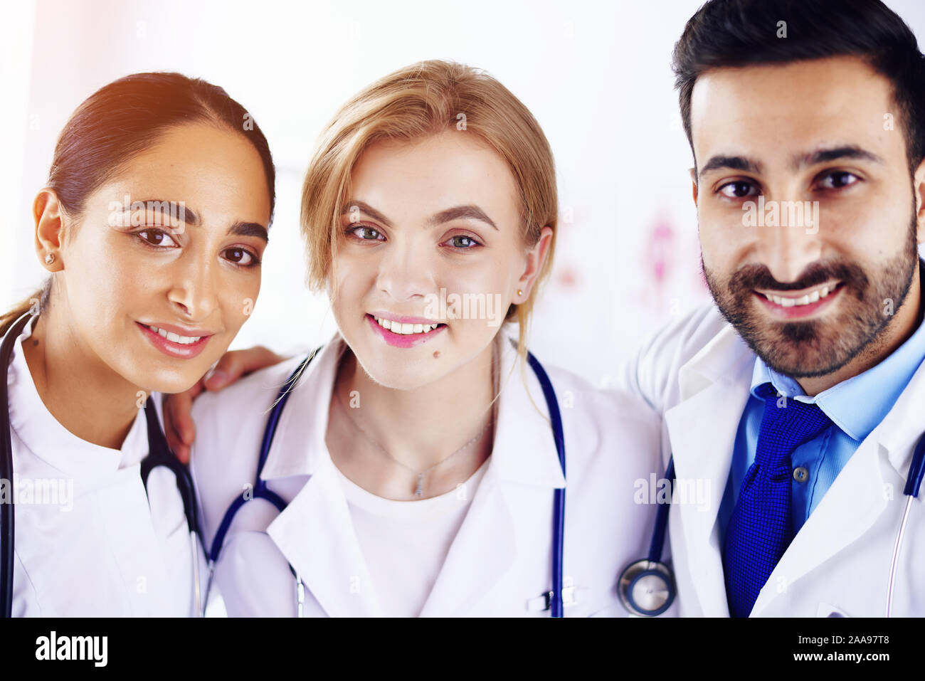 Three smiling doctors all standing together in a hospital. Multiracial ...