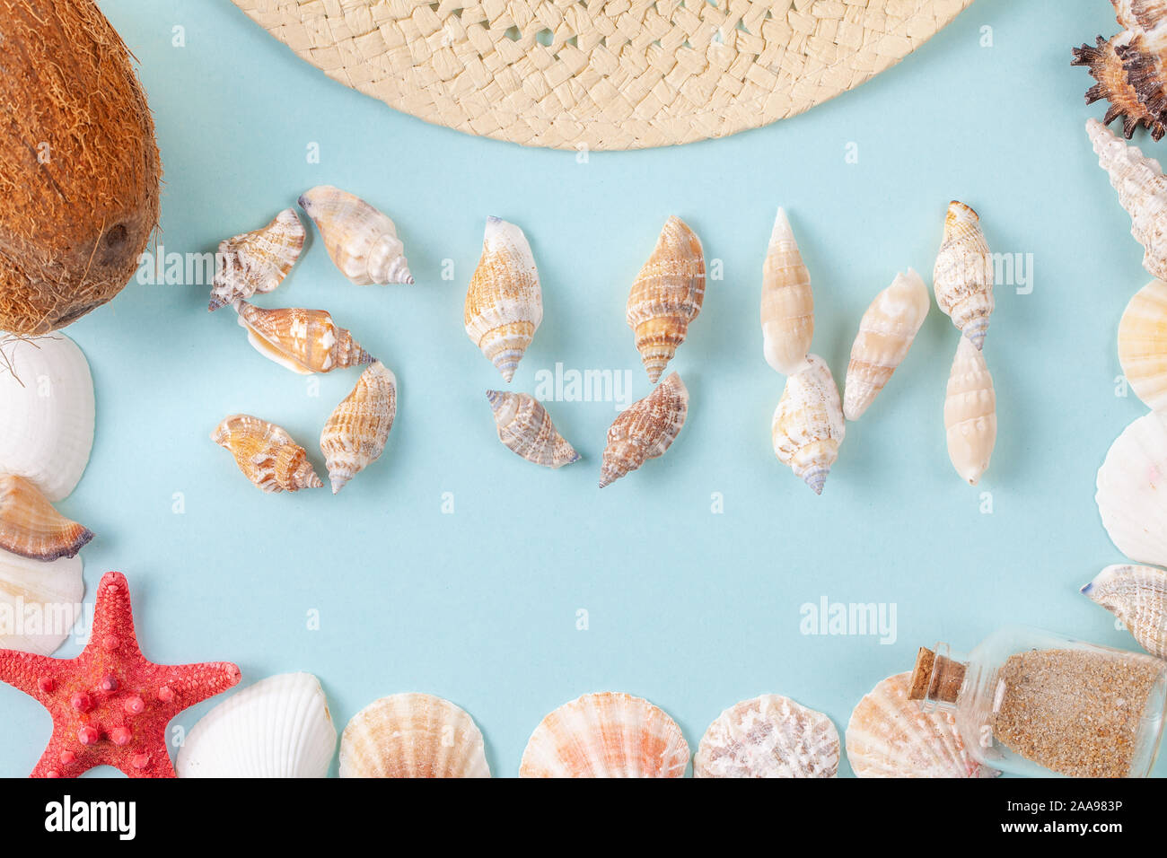 The word sun written in shells on blue background Stock Photo - Alamy