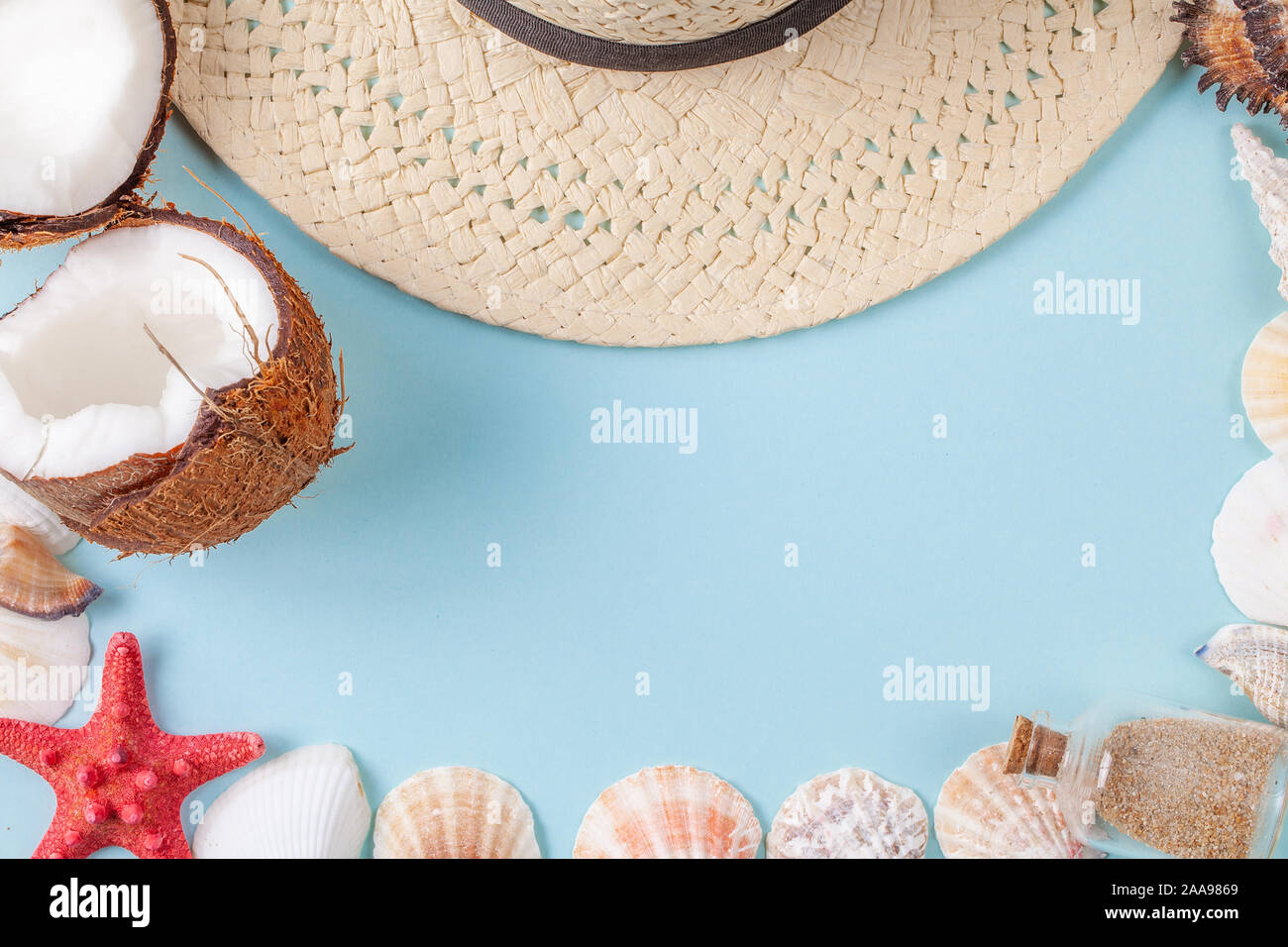 Flat lay composition with starfishes, sea shells, coconut and straw hat ...