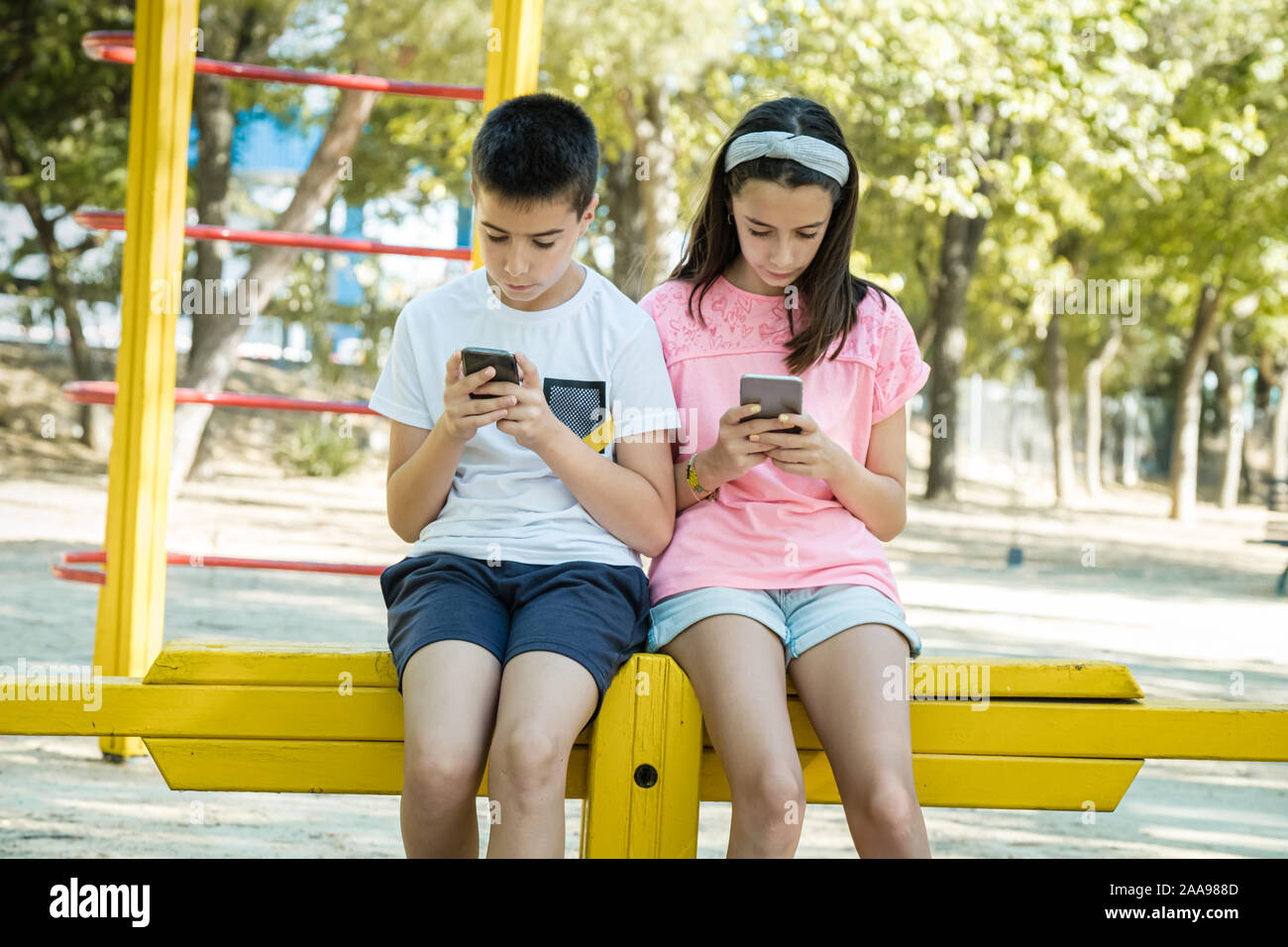 children looking at a mobile phone sitting in a yellow children's ...
