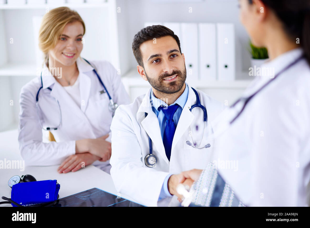 Young smiling arab doctor shakes hands with a nurse in a hospital ...