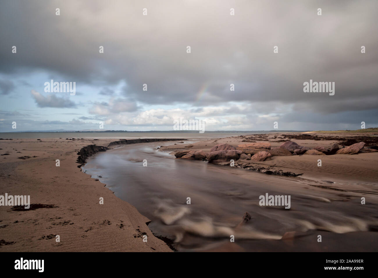 Stream flowing into Co Kerry beach after rain shower Stock Photo - Alamy