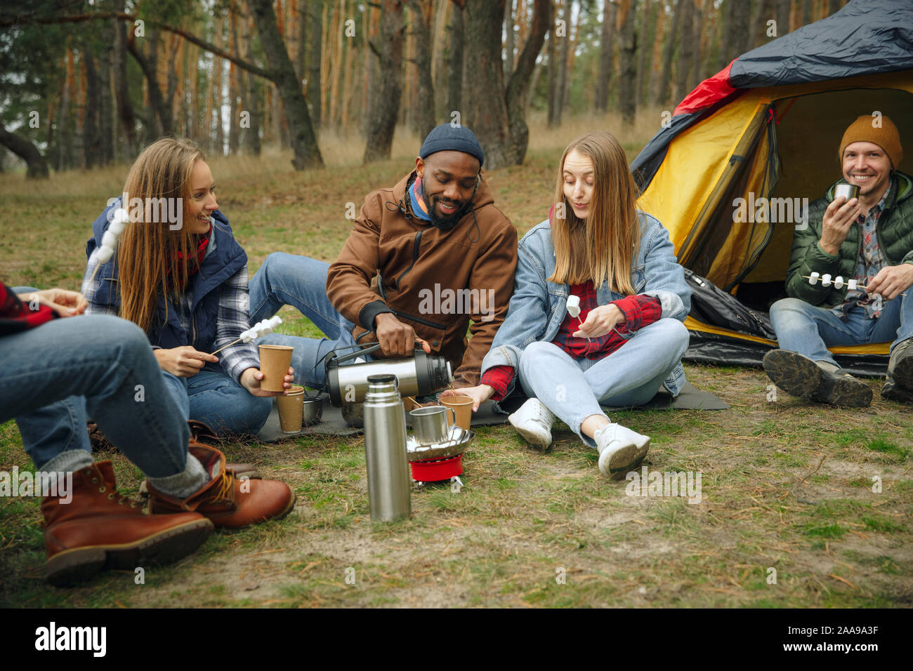Group of friends on a camping or hiking trip in autumn day. Men and ...