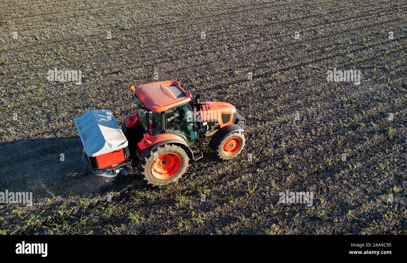 Tractor spreading artificial fertilizers in field Stock Photo - Alamy