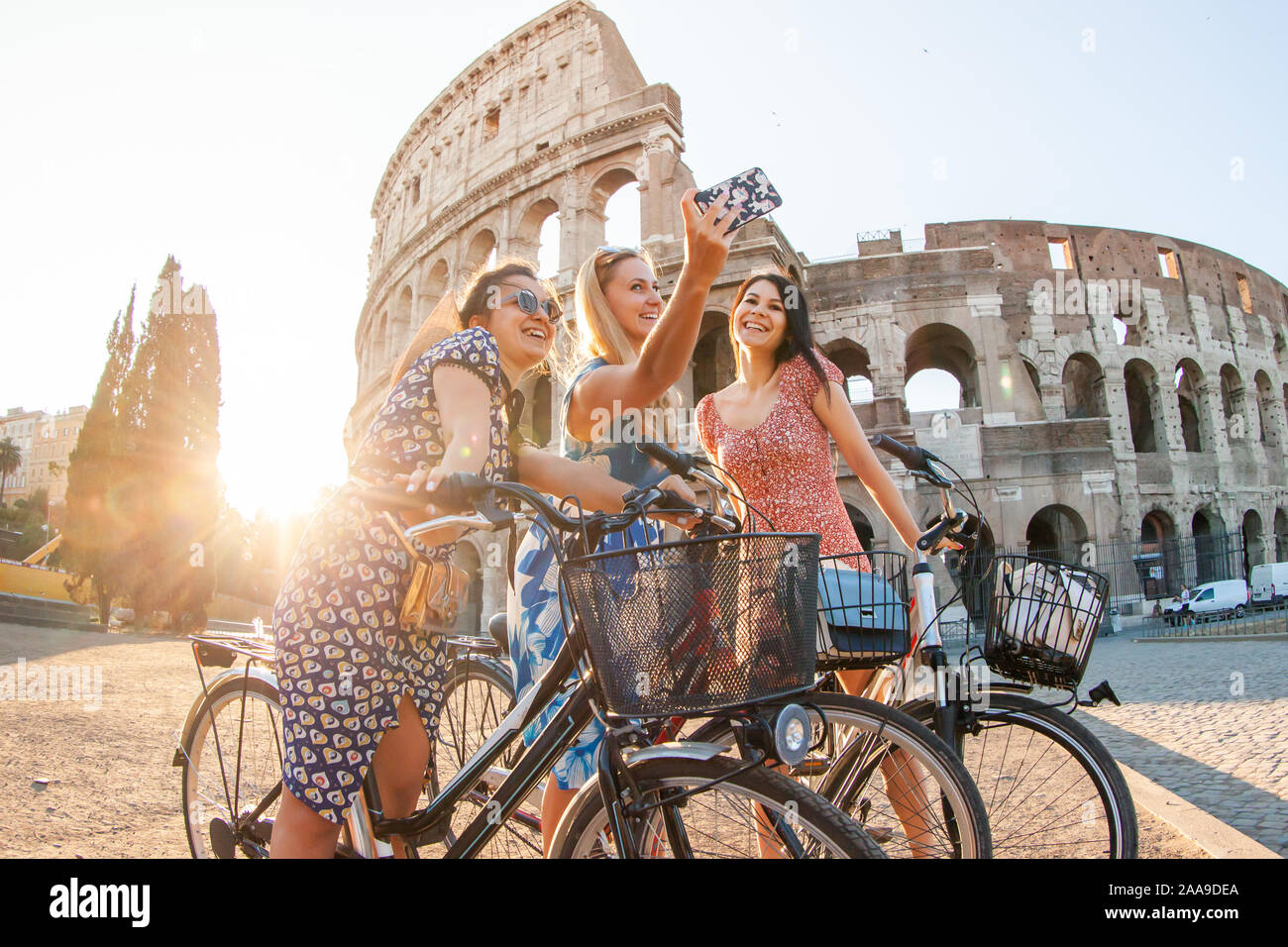 Three happy young women friends tourists with bikes taking selfies at ...