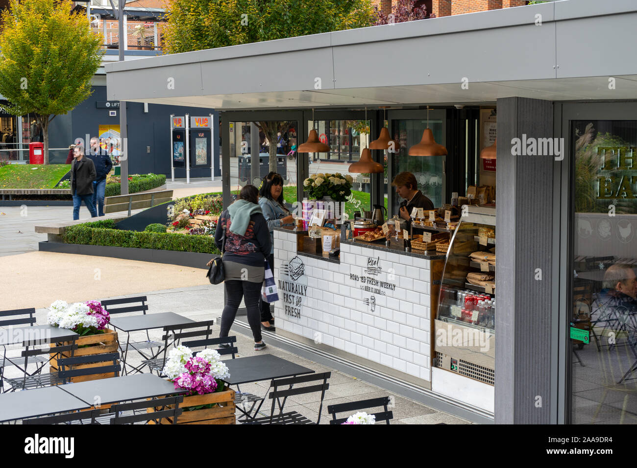 Two middle aged women ordering coffee from a Barista serving at an ...