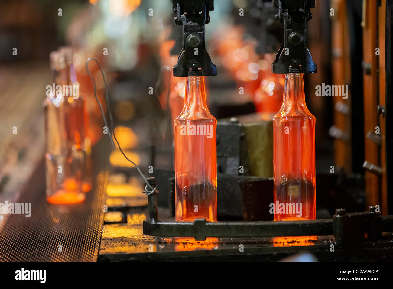 Glassworks. Glass industry. The process of making glass bottles.Molten ...