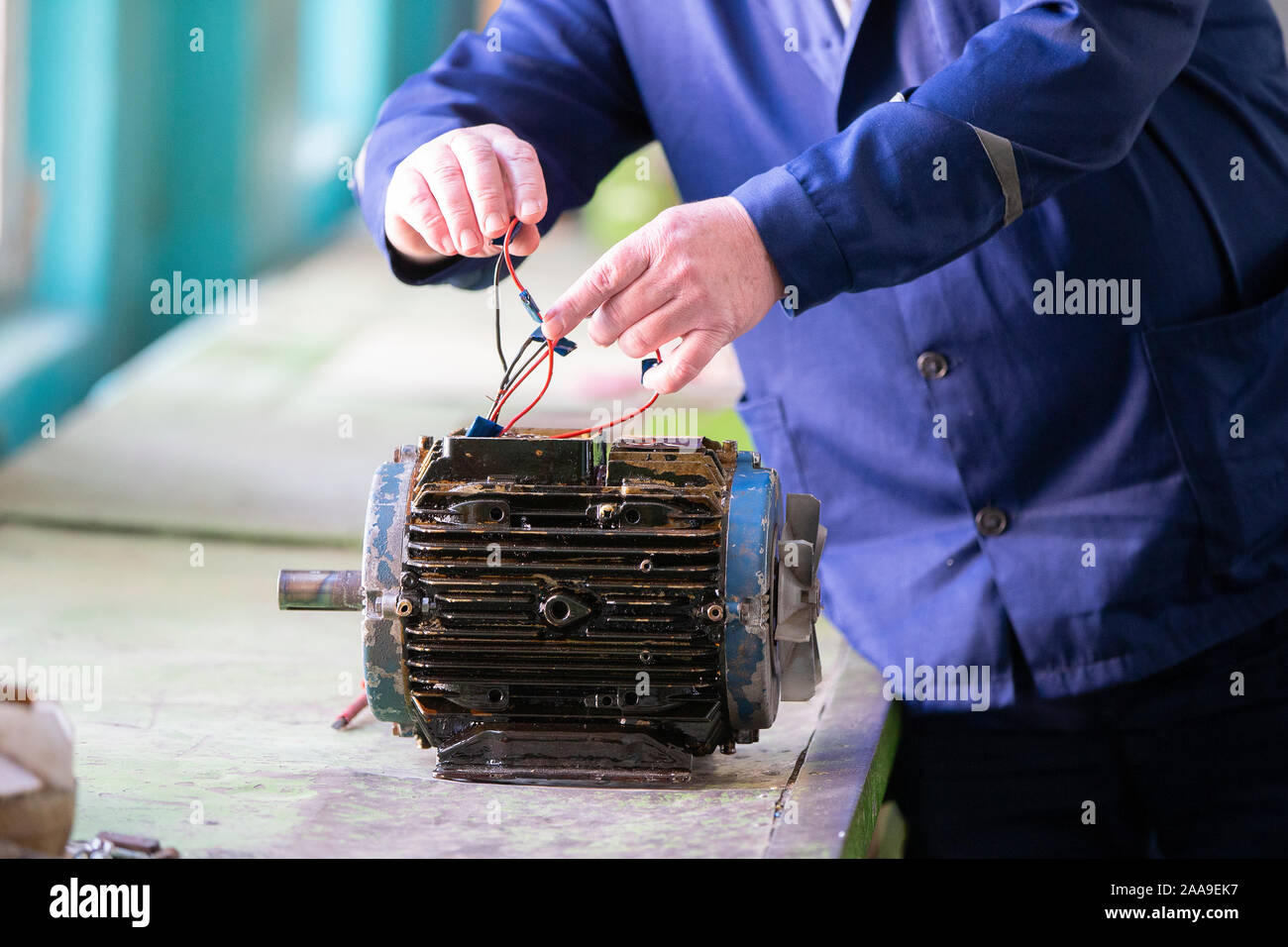 Worker's hands make an old electric motor Stock Photo - Alamy