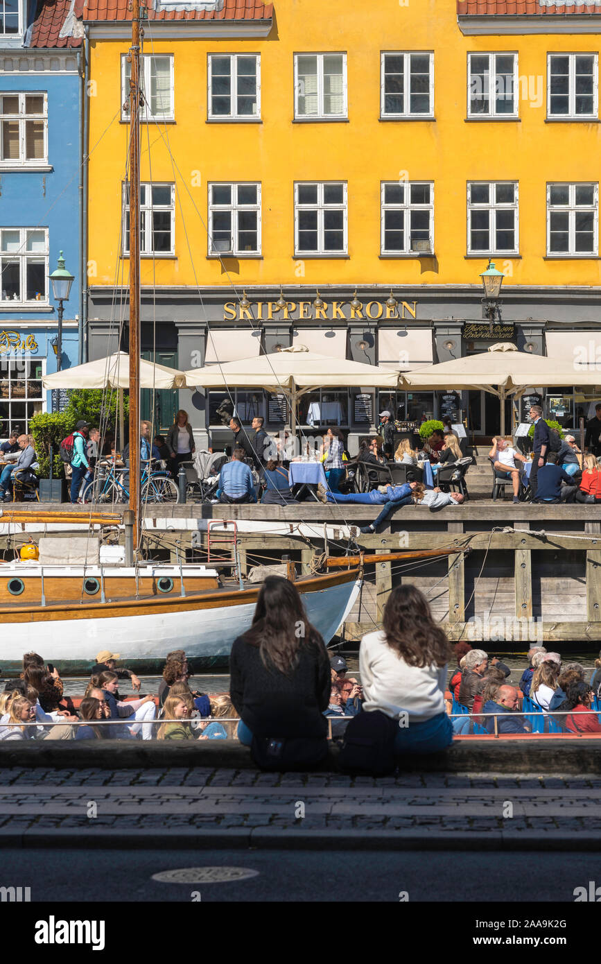 Copenhagen waterfront, view in late spring of two young women sitting ...