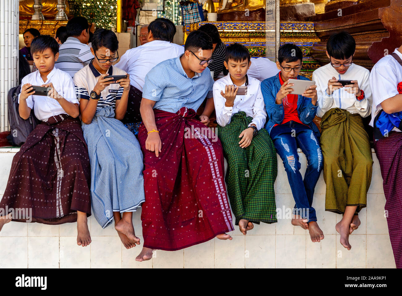 Young Burmese Teenagers Playing With Their Mobile Phones At The ...