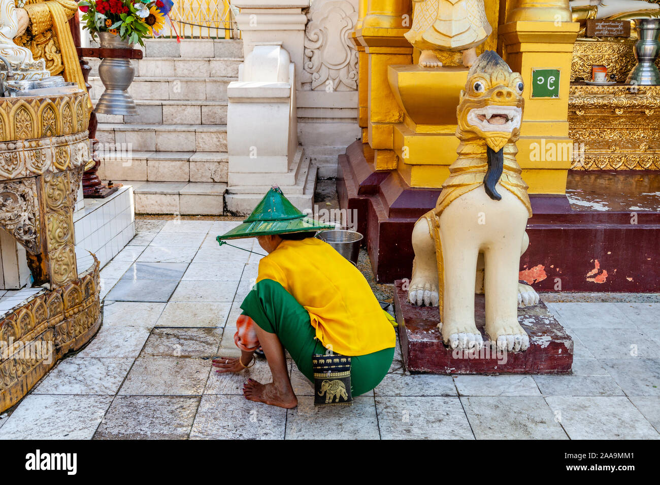A Colourfully Dressed Woman Cleaning The Floor At The Shwedagon Pagoda ...