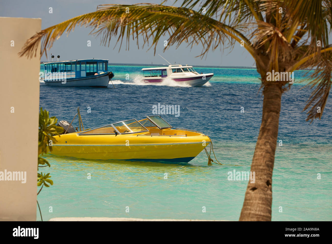 Yellow speed boat in the harbour of beautiful turquoise indian ocean ...