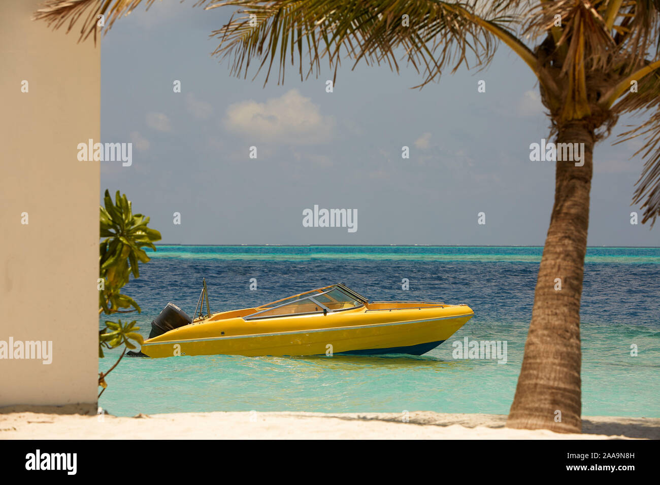 Yellow speed boat in the harbour of beautiful turquoise indian ocean ...