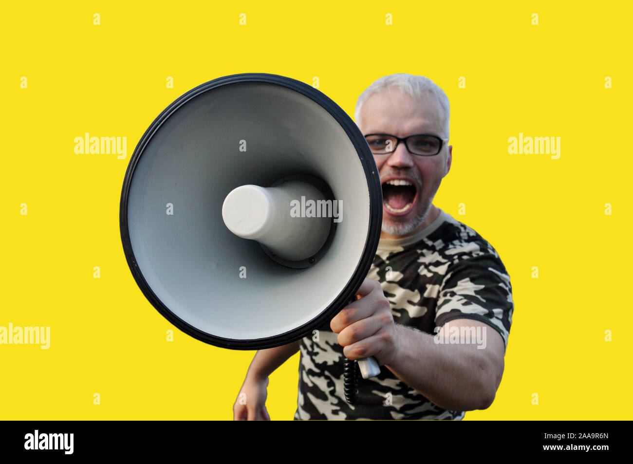 Closeup portrait of a young man screaming into a megaphone. isolate on ...