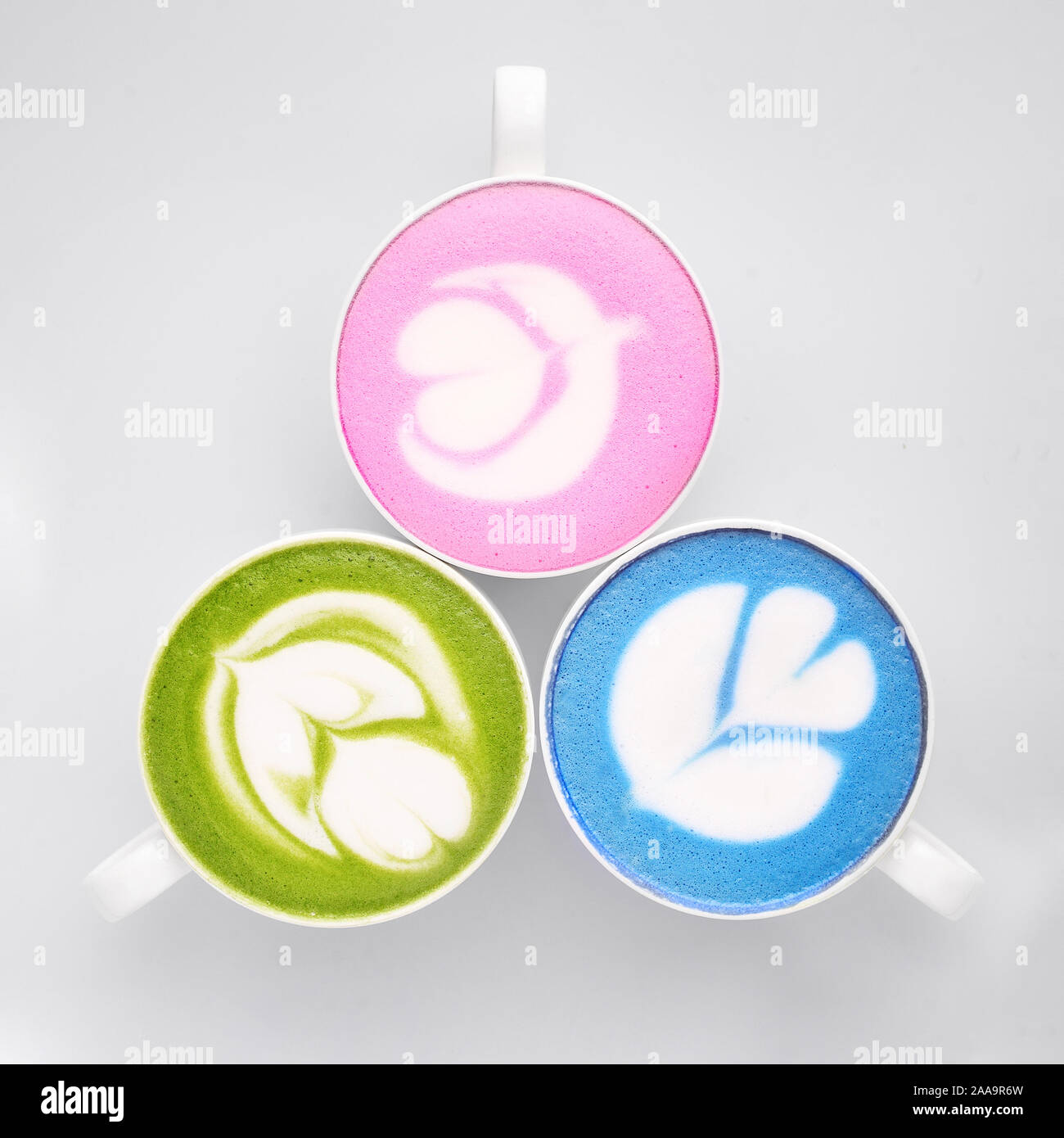 Three matcha tea cups at white background. Green, pink and blue matcha ...