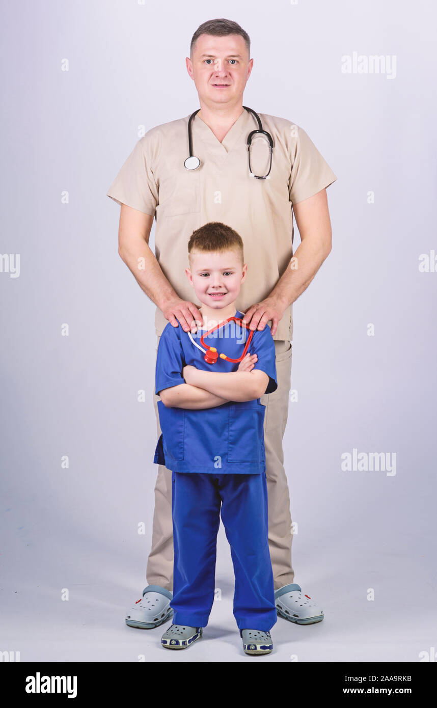 little boy with dad in hospital. father and son in medical uniform ...