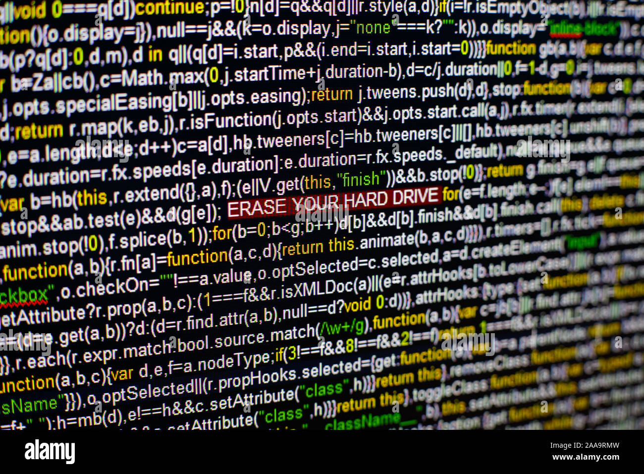 Macro photo of computer screen with program source code and highlighted ERASE YOUR HARD DRIVE ...