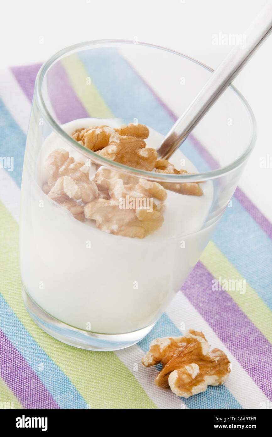 Yogurt and walnuts with spoon Stock Photo - Alamy
