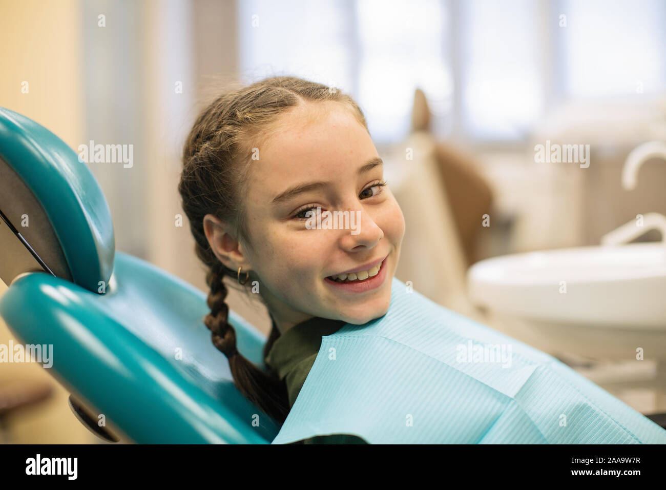 Portrait of happy cute patient girl in the dental room. Health care ...