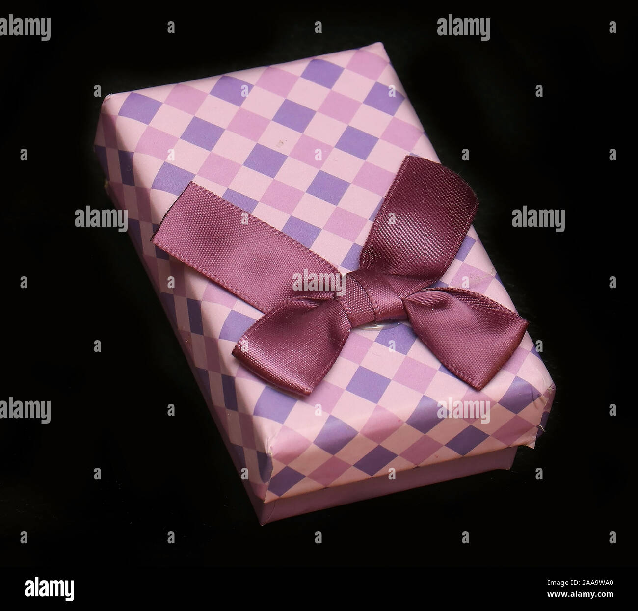 Decorative closed gift box with purple bow Stock Photo - Alamy