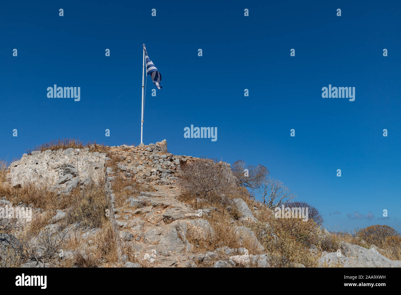 Greek flag and ruins over a mountain in Hydra Island, Greece Stock ...