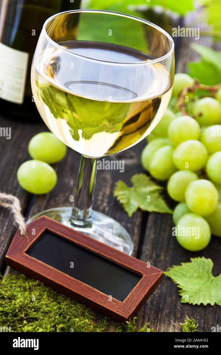 White wine on wooden table with label Stock Photo - Alamy