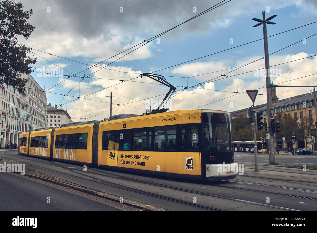 yellow tram driving on a city street Stock Photo - Alamy