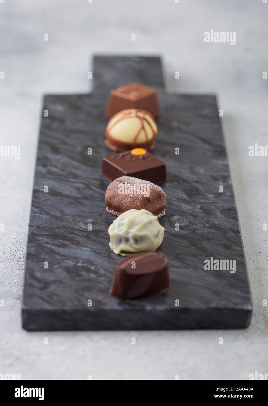 Luxury Chocolate candies selection on black marbel board. White, dark ...