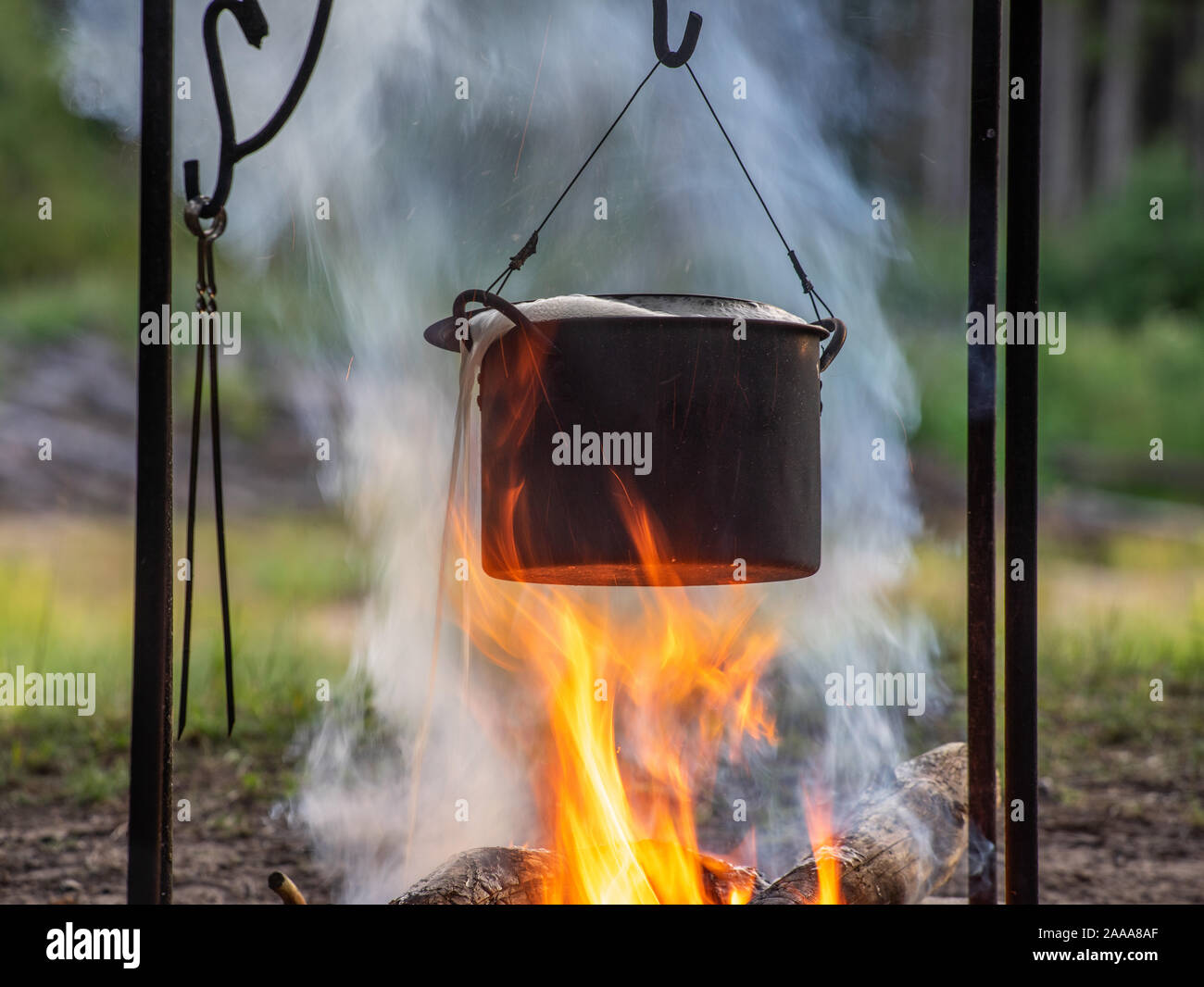 Boiling soup in a pot on the fire. Dinner in nature. Camping Stock ...