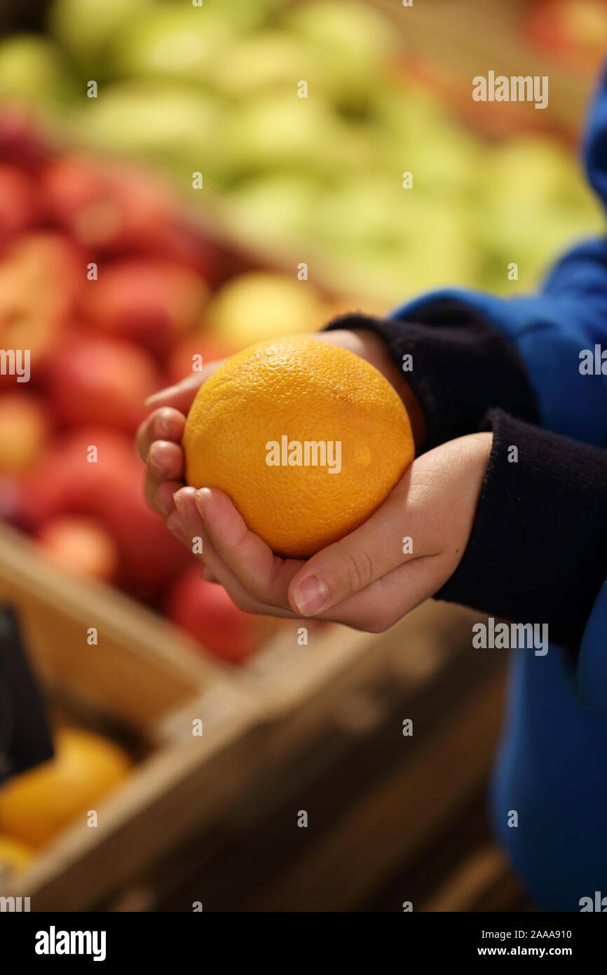 Children's hands hold an orange Stock Photo - Alamy