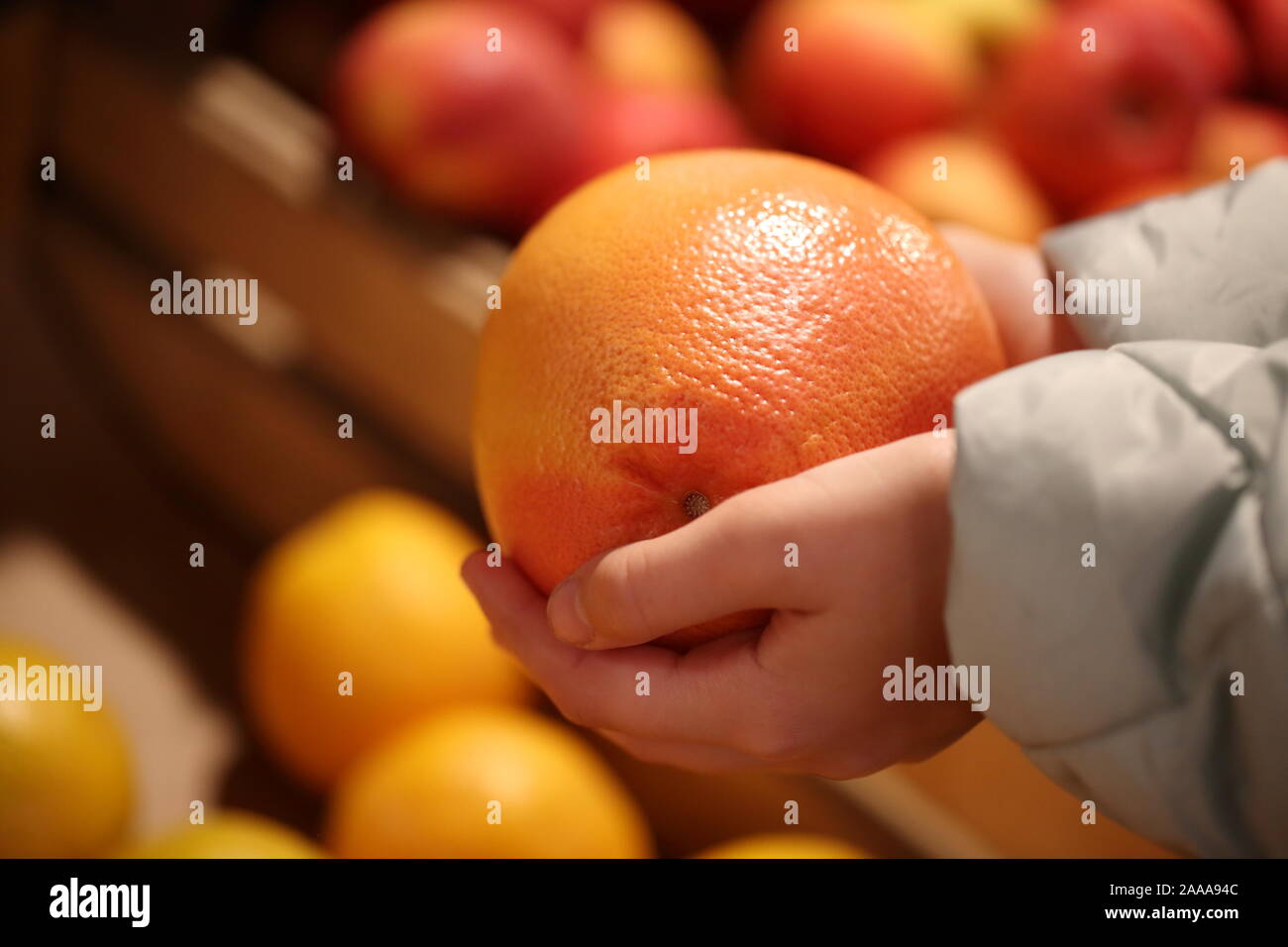 Baby hands holding grapefruit Stock Photo - Alamy