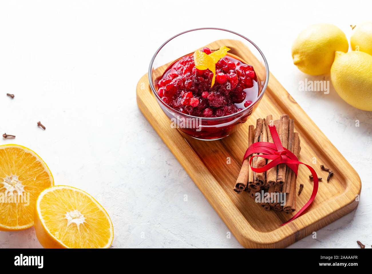 Thanksgiving cranberry sauce in glass bowl with fresh orange fruit and ...