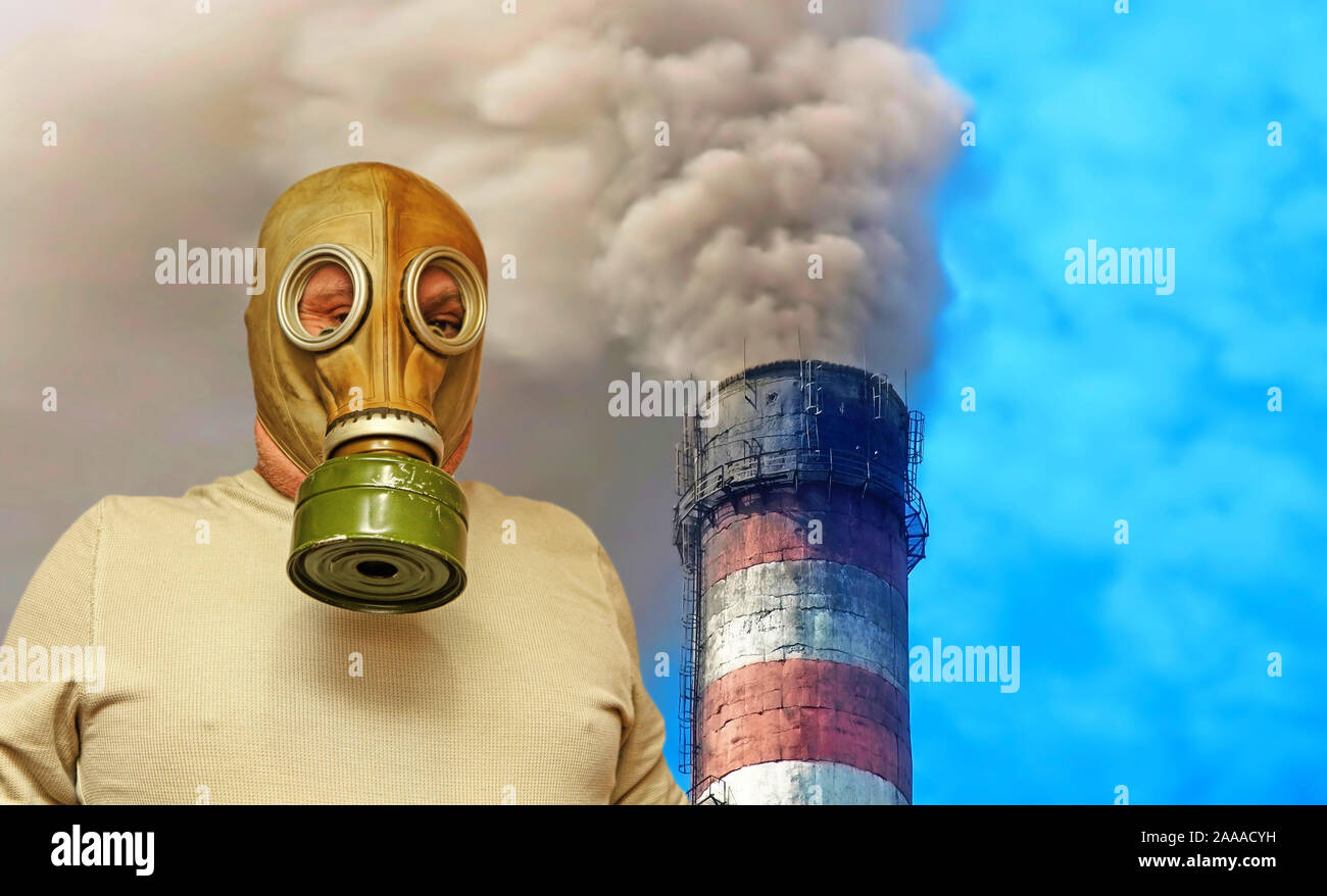 Men in gas mask taken closeup on industrial smoking pipe and sky ...