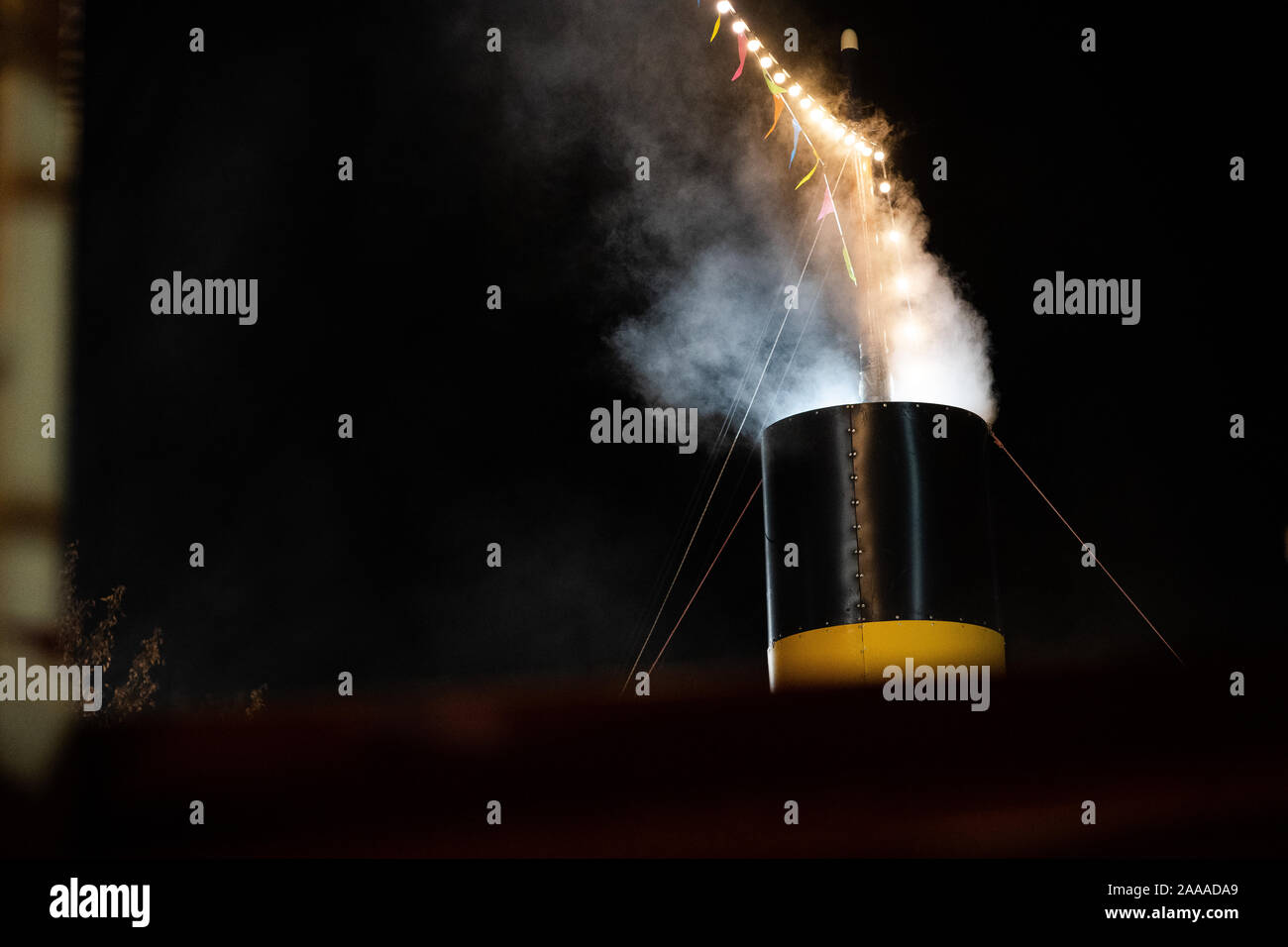 Steam coming out of the pipe of a vintage steamship at night ...