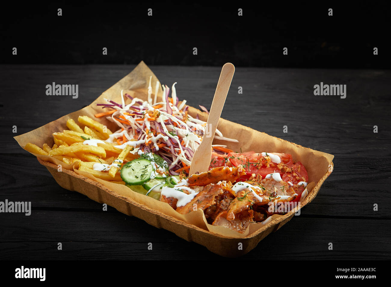 Cardboard box filled with barbecue food: kebab, vegetables, french ...