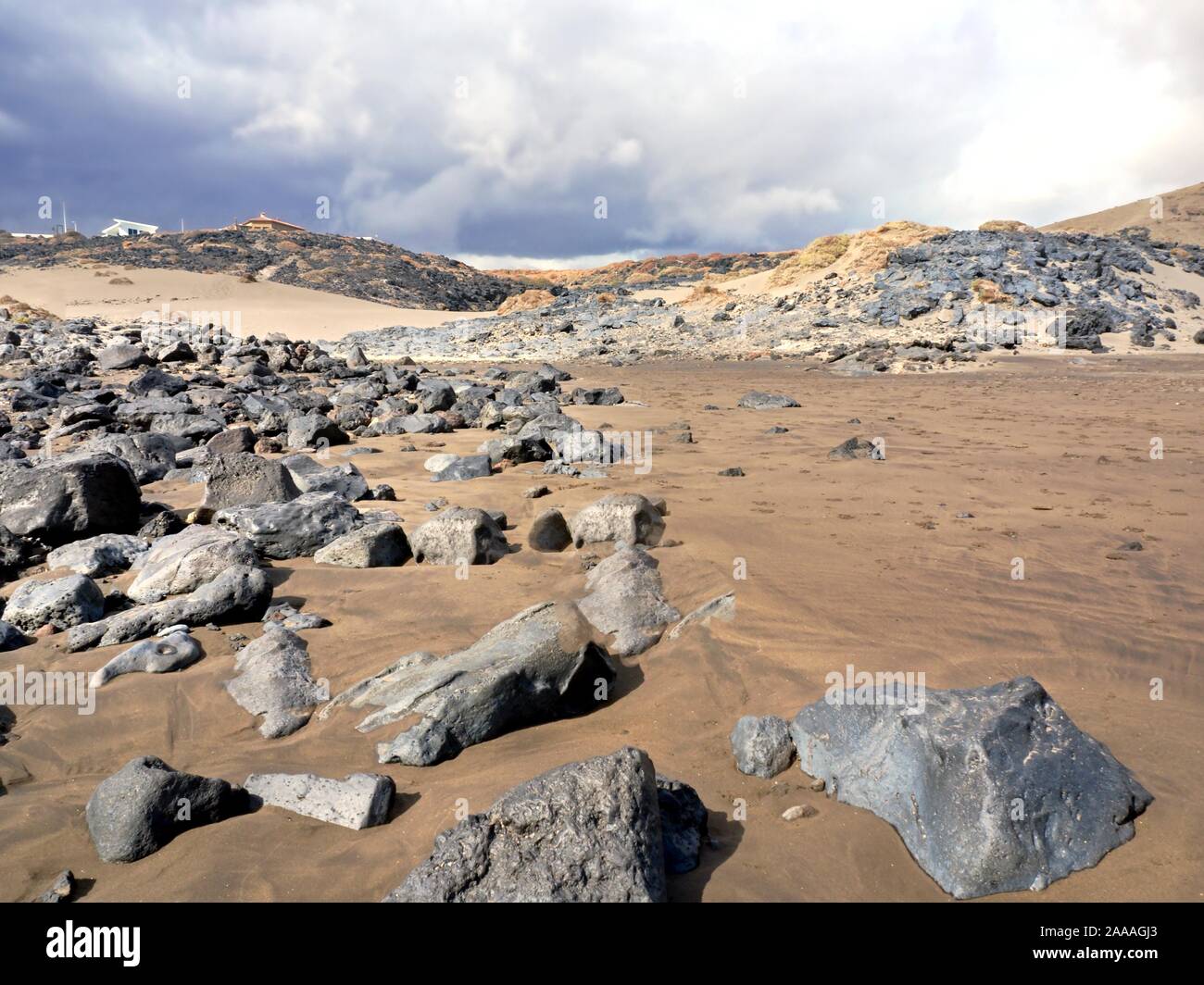 Lava sand beach with large black lava stones lying around on Tenerife ...