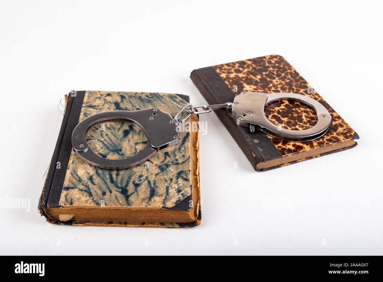 Old books and metal handcuffs. Literature and prison for bad words ...