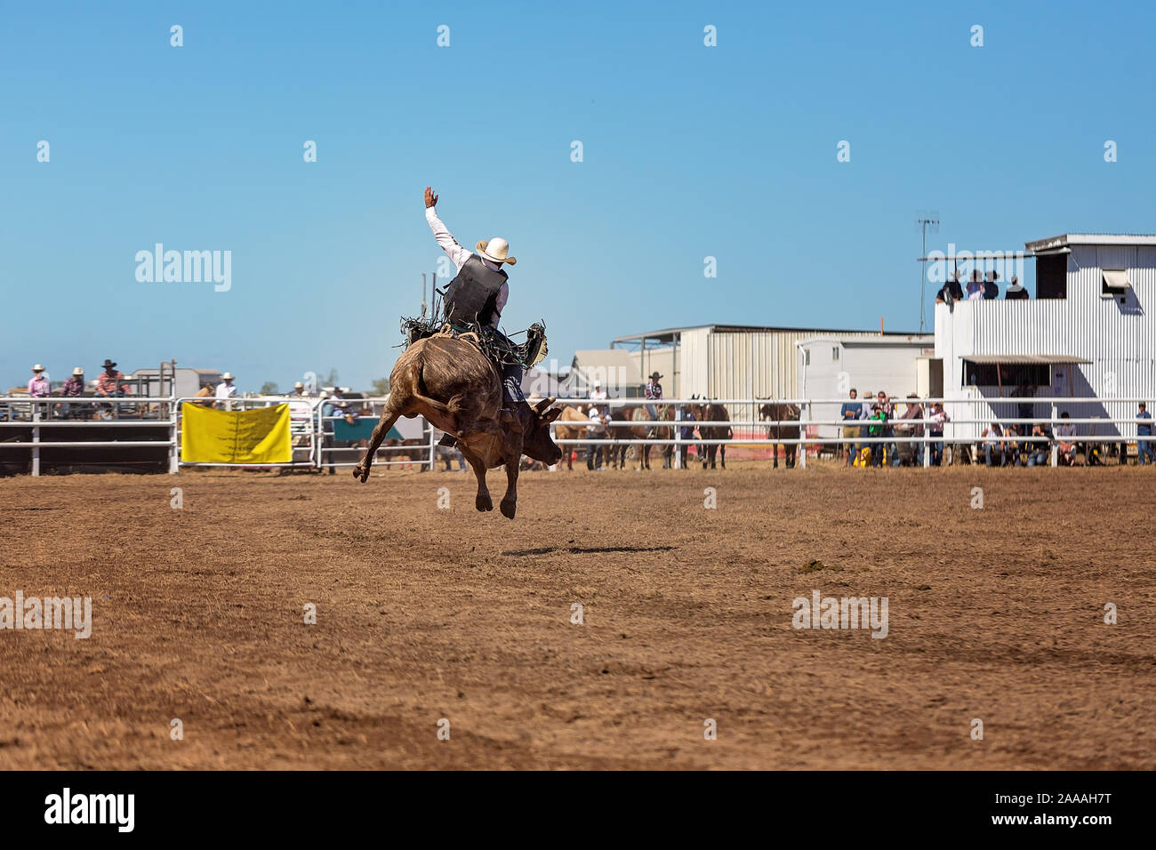 A cowboy competing in the bull riding event at a country rodeo Stock ...
