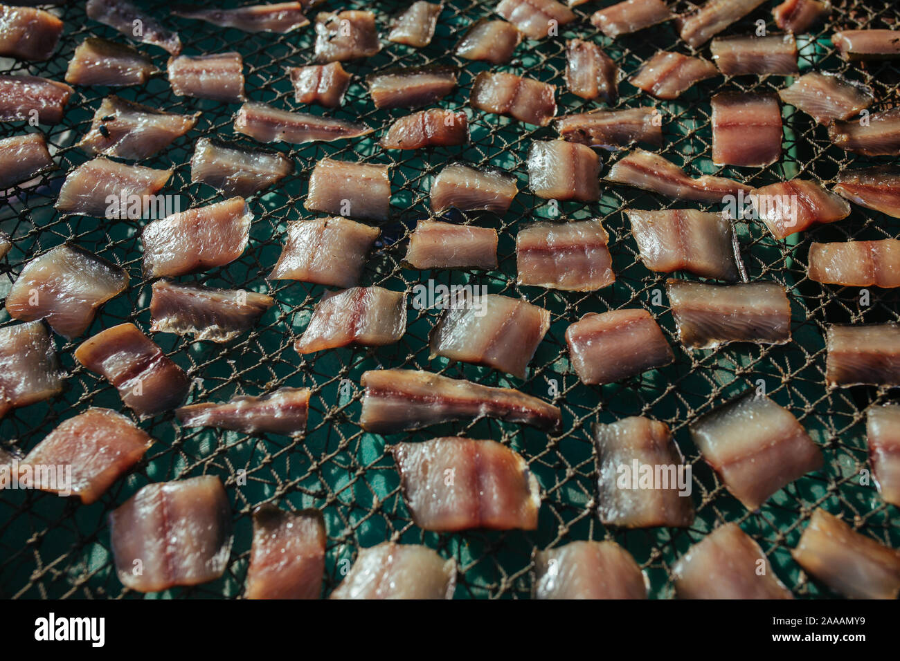 Fish Dried on the fishing net on the street in Asia Stock Photo - Alamy