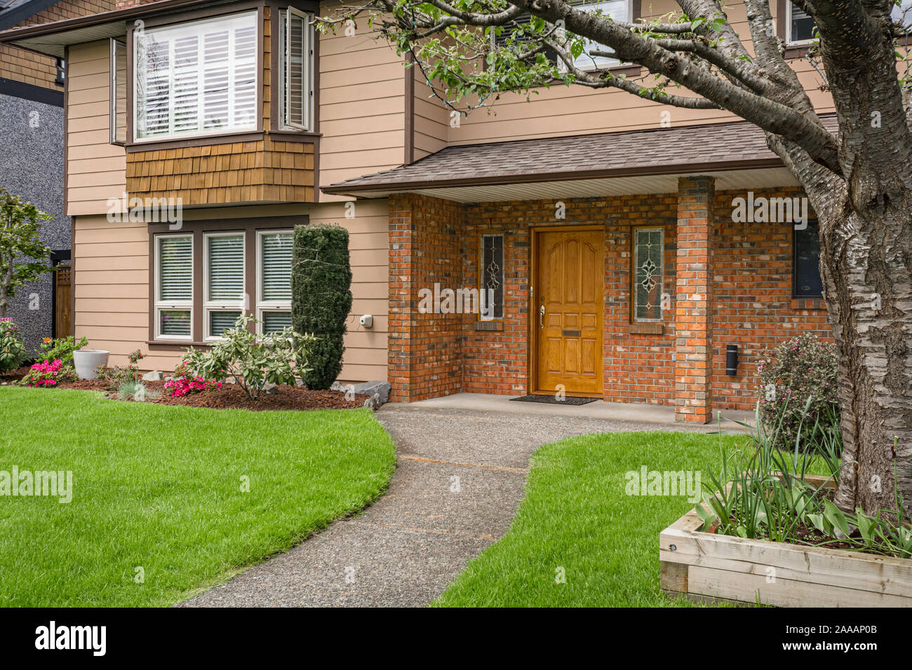 Nice main entrance of old family house with concrete pathway over front ...