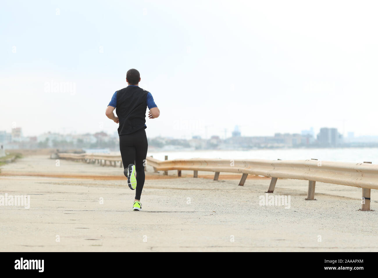 Back view full body portrait of runner jogging on the beach Stock Photo ...