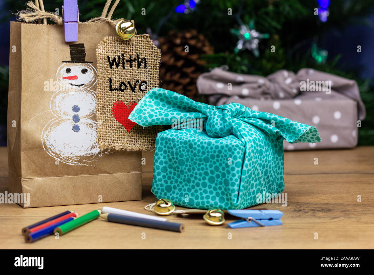 Recycled paper gift bag with child's drawing with fabric wrapped gifts ...