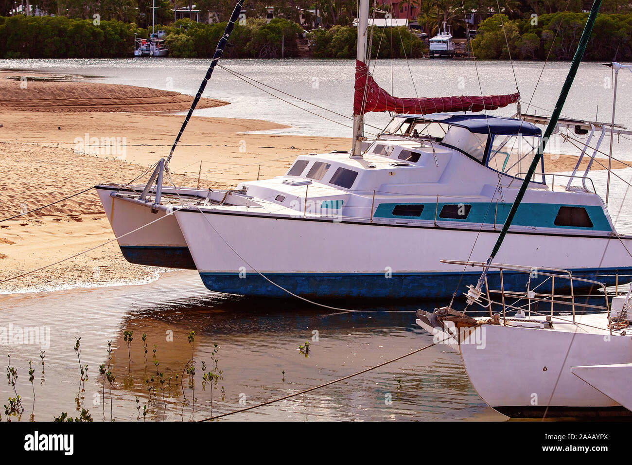 Boats moored on a sandy beach with tide out Stock Photo - Alamy