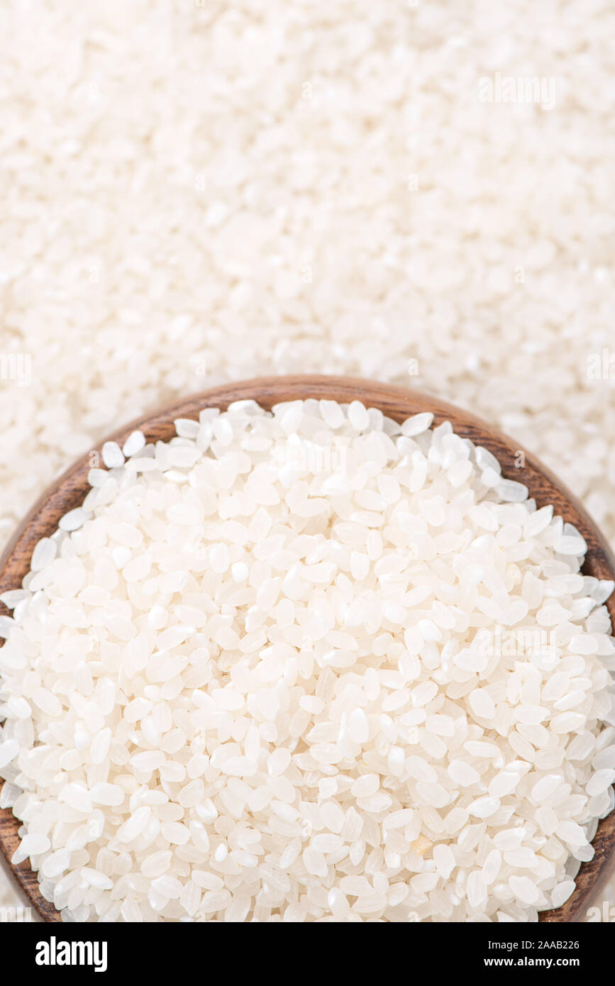 Raw white polished milled edible rice crop on white background in brown ...