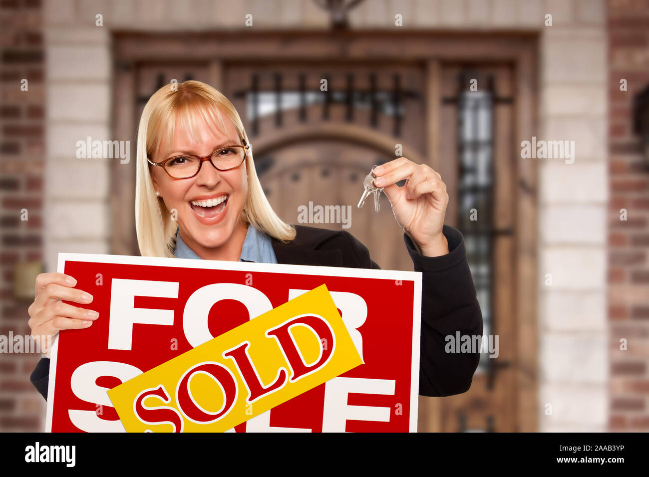 Female realtor holding sold sign hi-res stock photography and images ...
