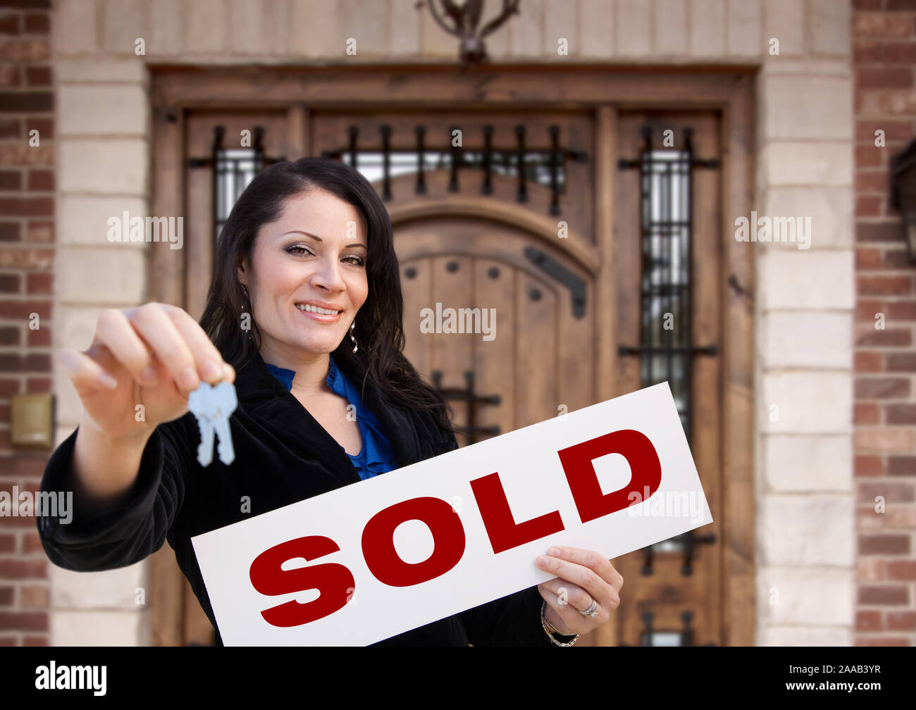 Hispanic Woman Holding Sold Sign and Keys In Front of House Stock Photo ...