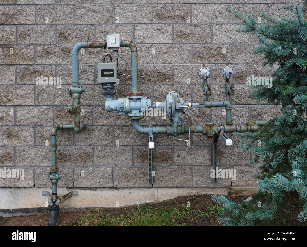Natural gas building entrance meter pipe system against a brick wall ...