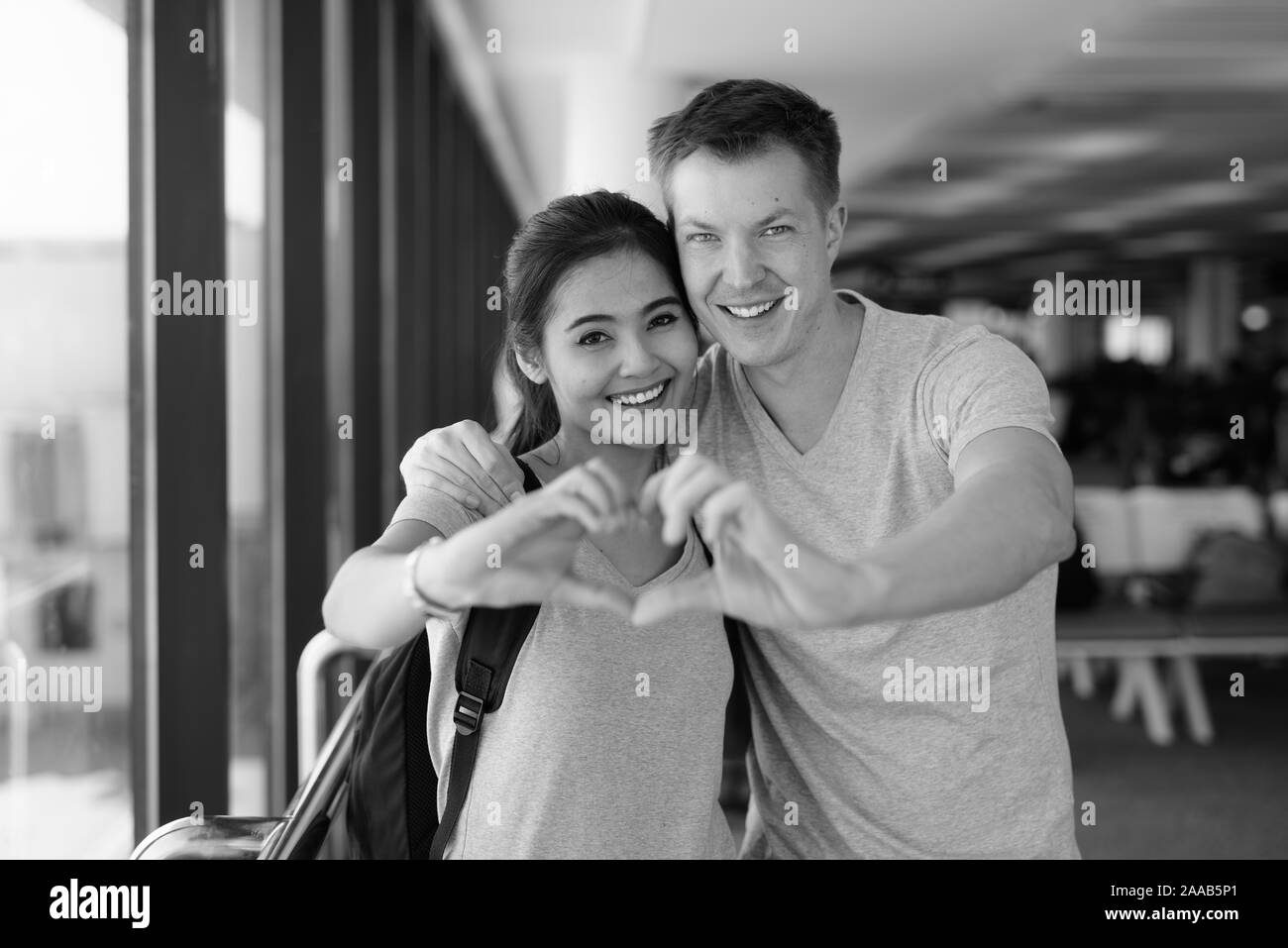 Portrait of happy young multi ethnic couple enjoying vacation together ...