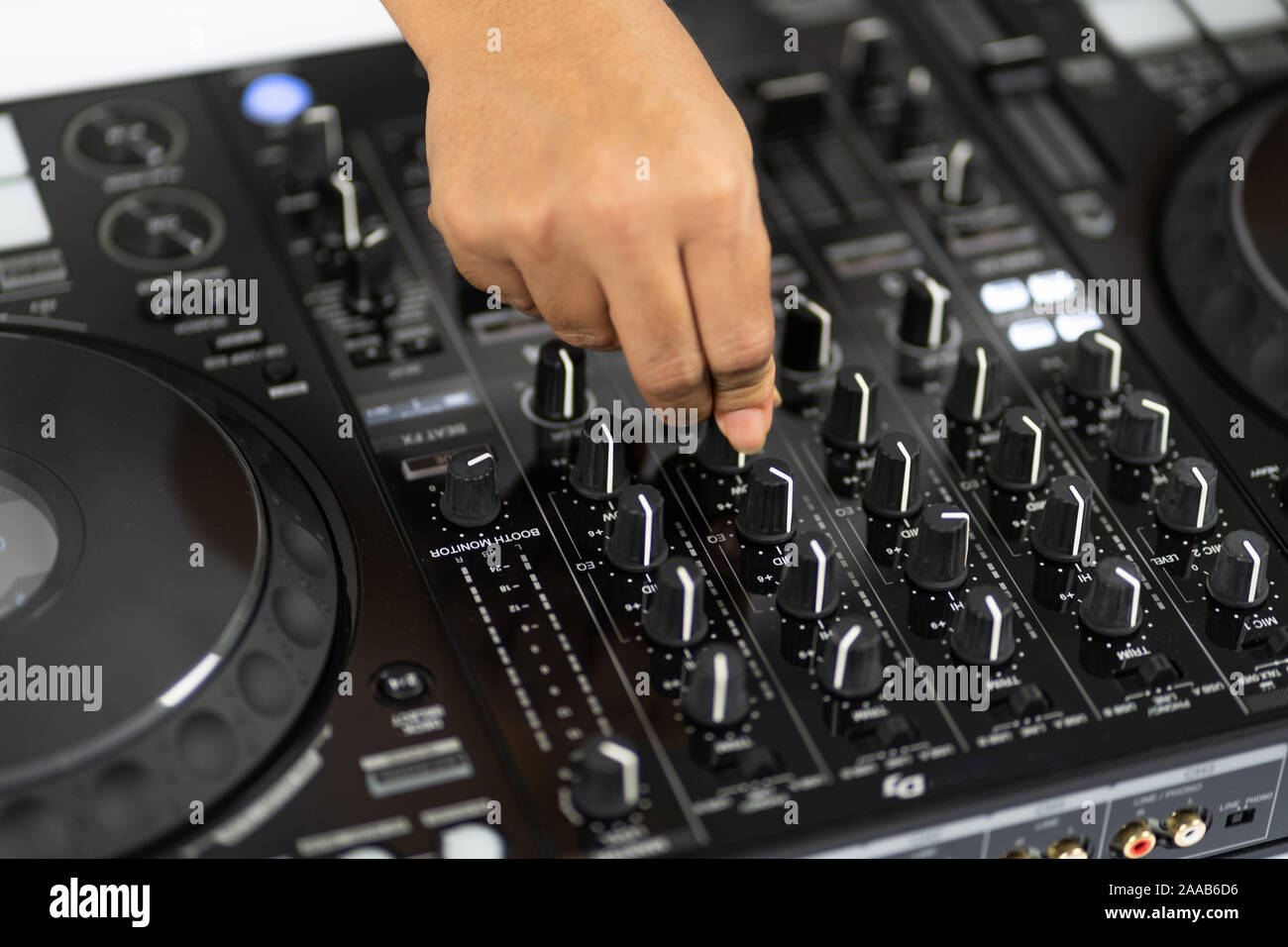 Hands of DJ mixing tracks on professional sound mixer.Fashionable rings ...