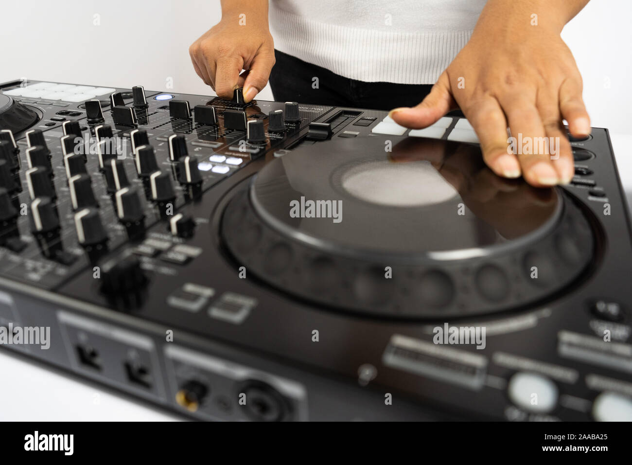 Hands of DJ mixing tracks on professional sound mixer.Fashionable rings ...